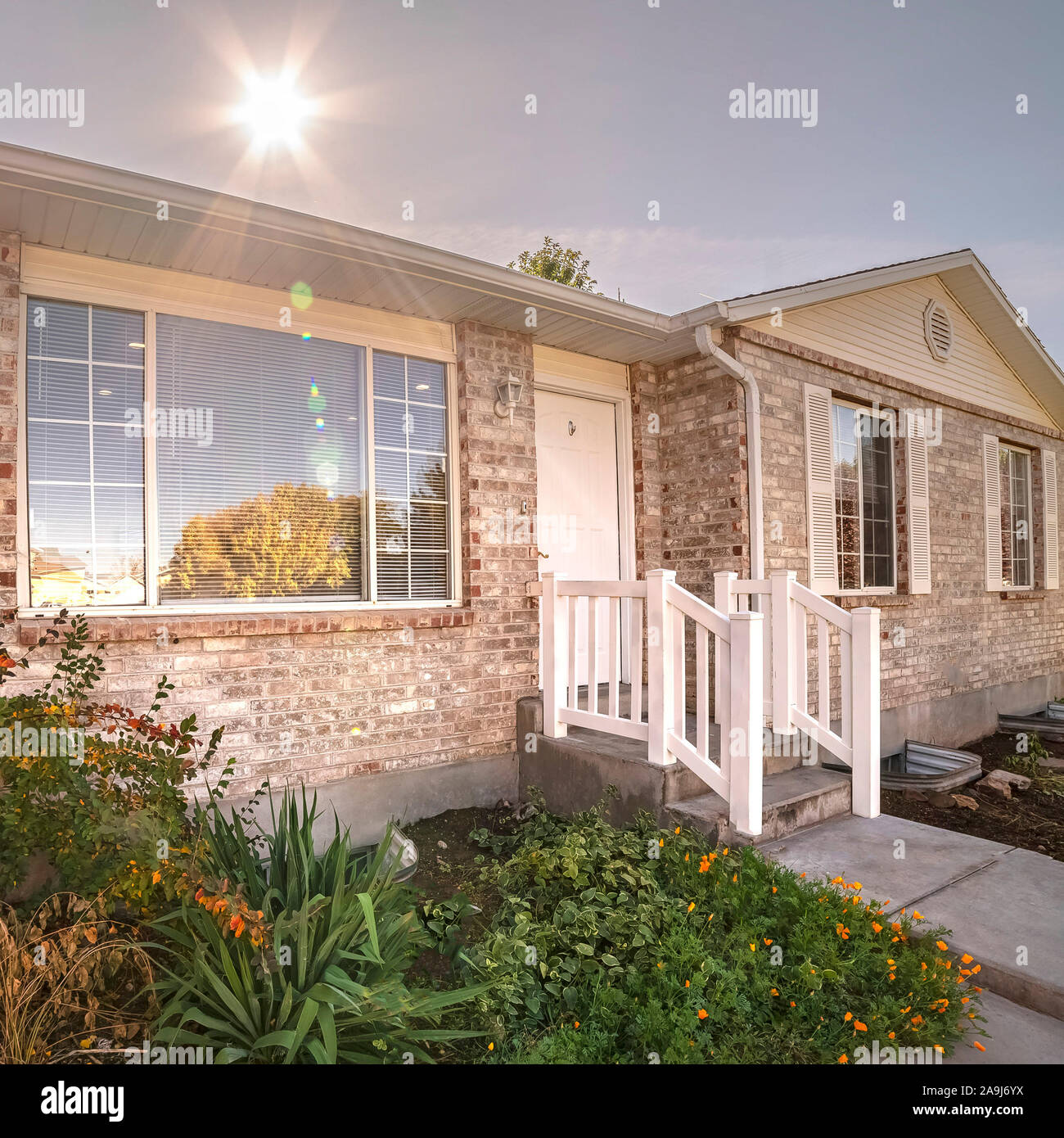 Square Face brick home with white railing leading to door Stock Photo ...