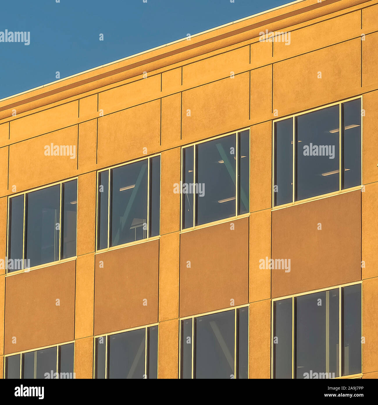 Square Modern building exterior viewed on a sunny day against clear ...