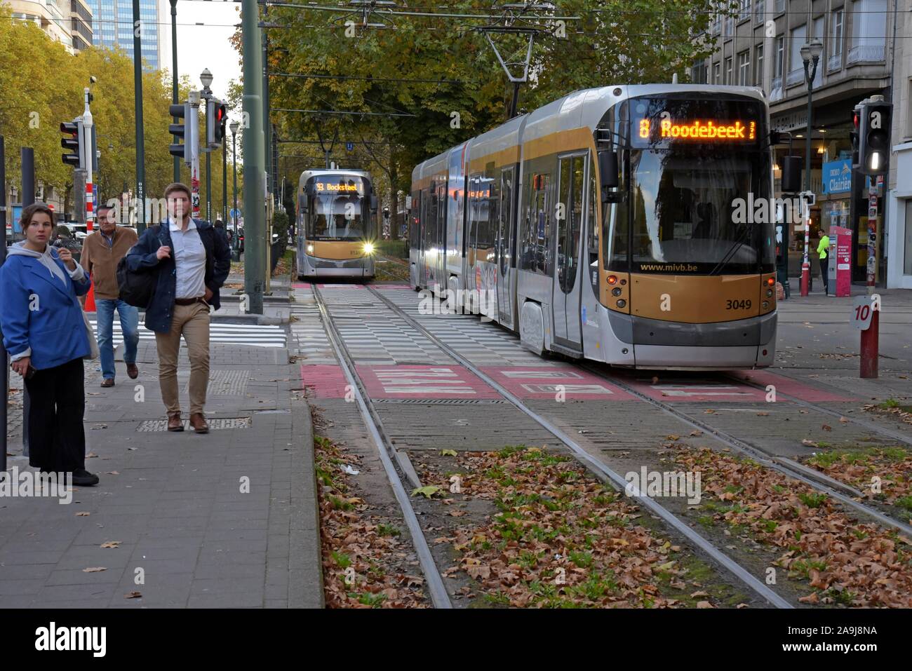 Passengers waiting whilst two trams pass at Bailli tram stop, Avenue ...