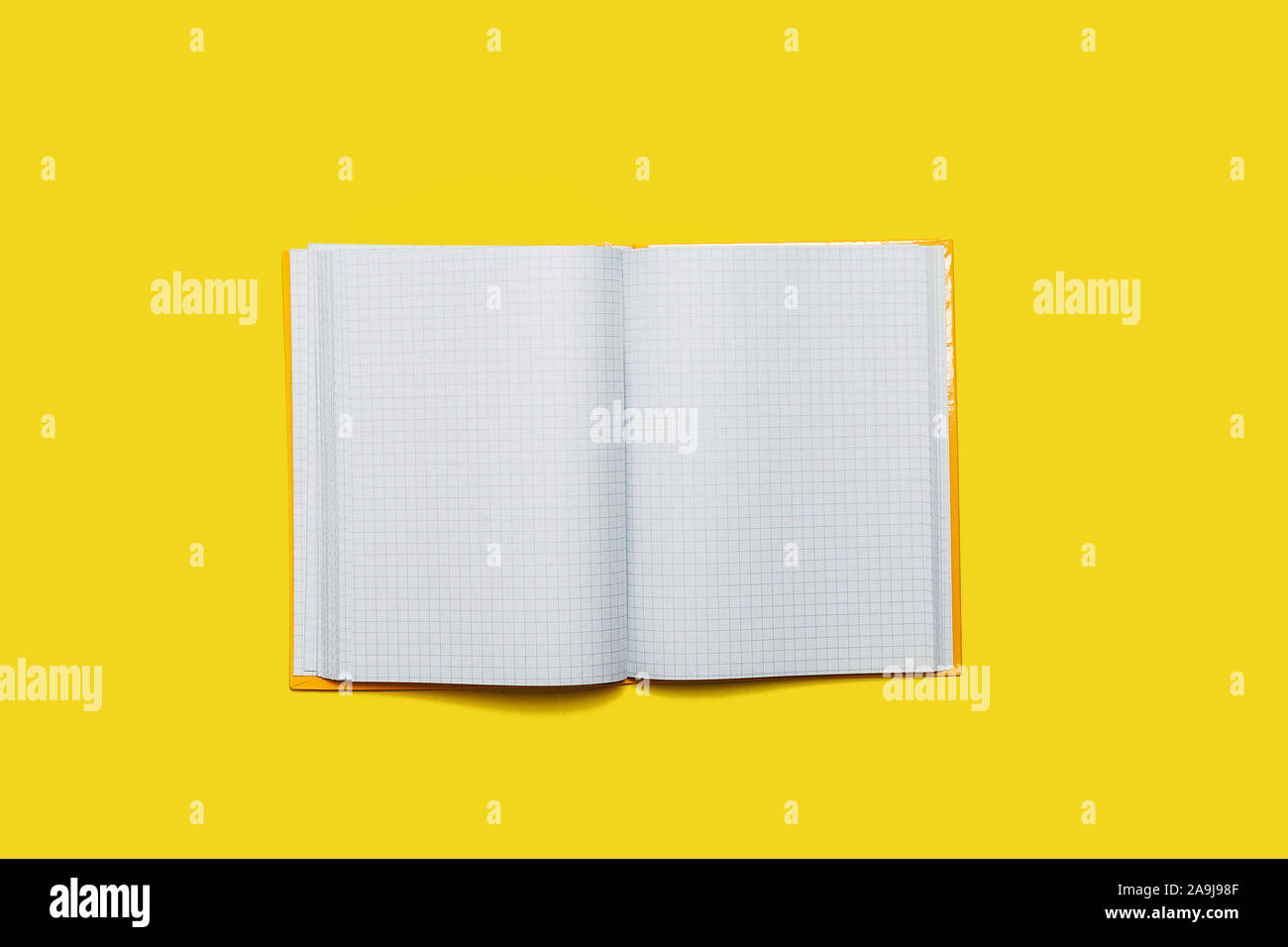 opened workbook on a yellow surface Stock Photo - Alamy