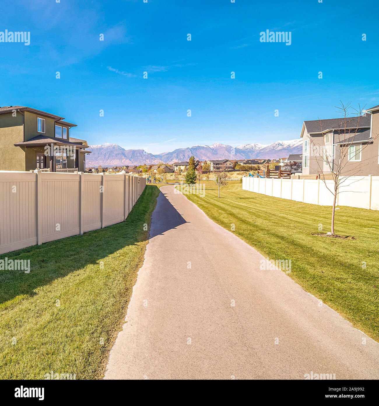 Square frame Long pedestrian walkway between walled houses during day ...