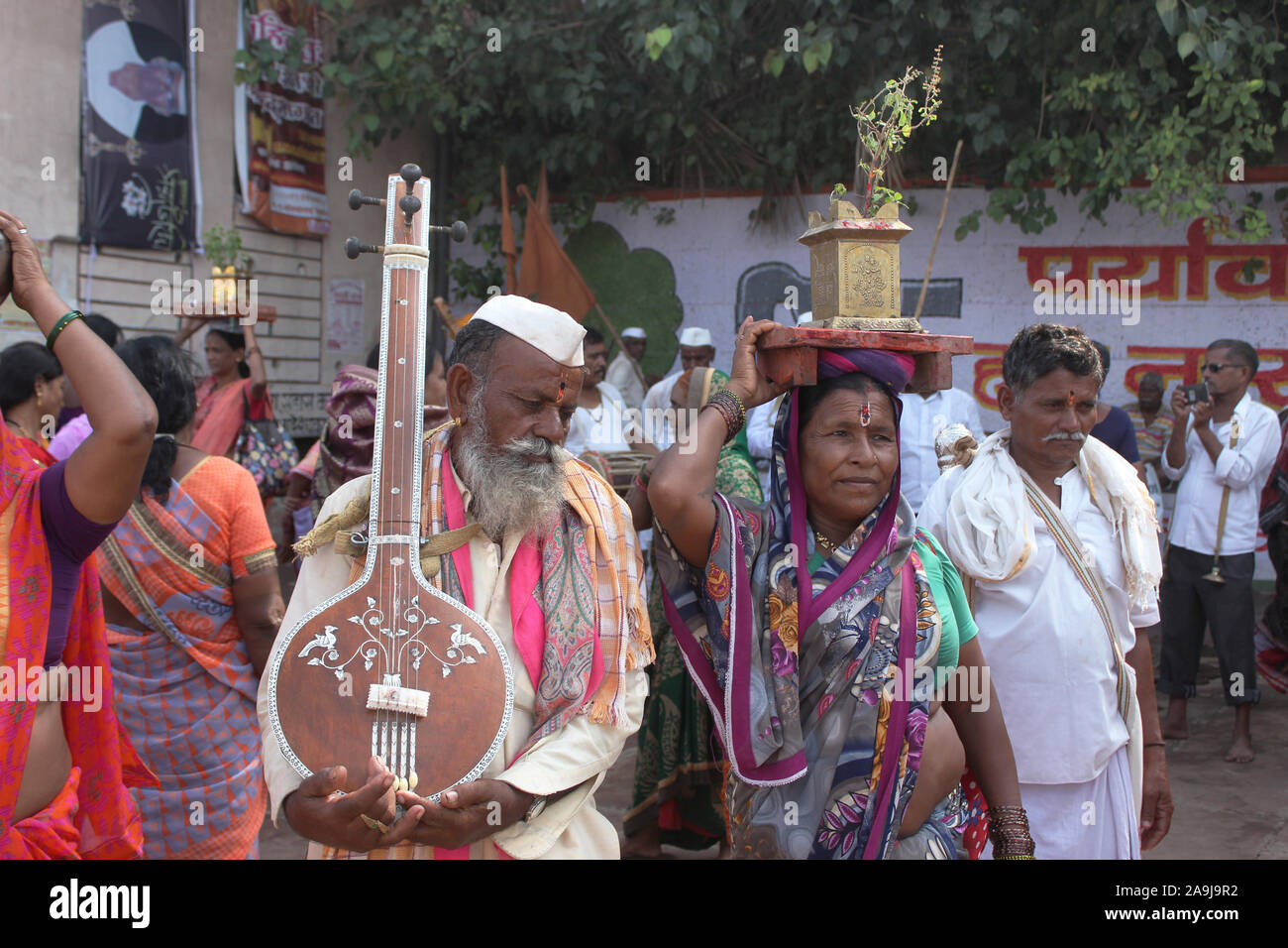 Man carrying harp and woman carrying tulsi during Alandi yatra, Alandi ...
