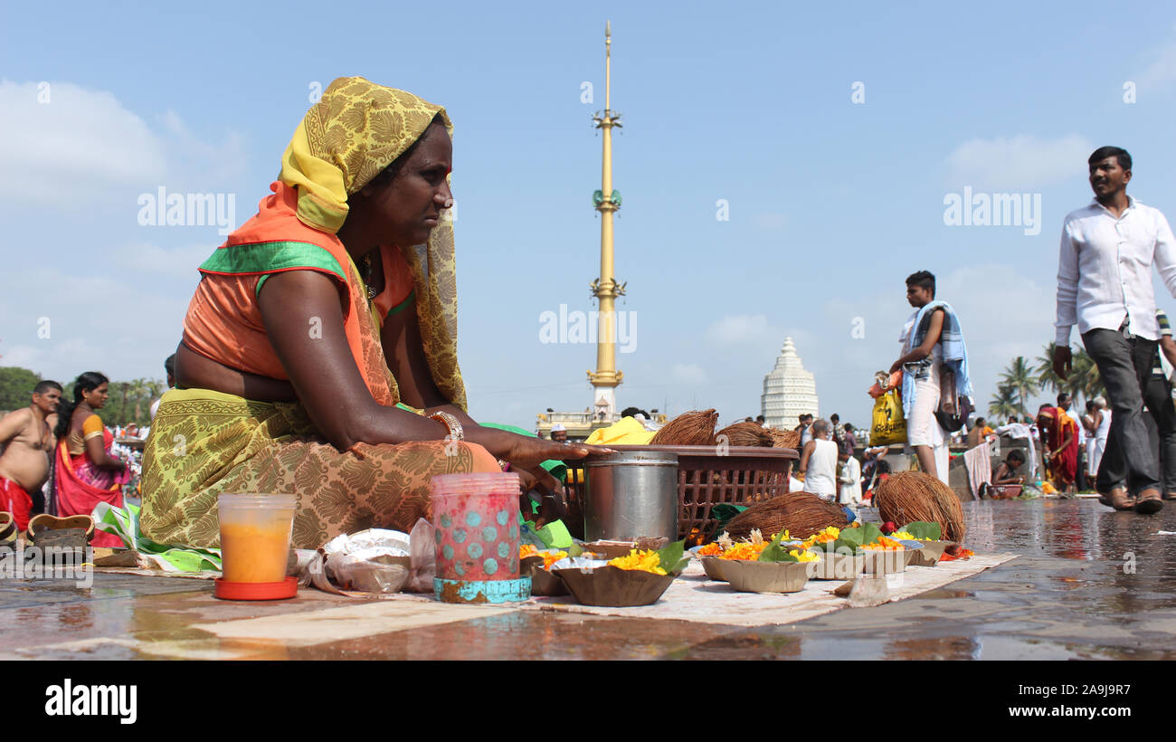 Vendor woman selling flowers and coconut for offerings to God, Alandi ...