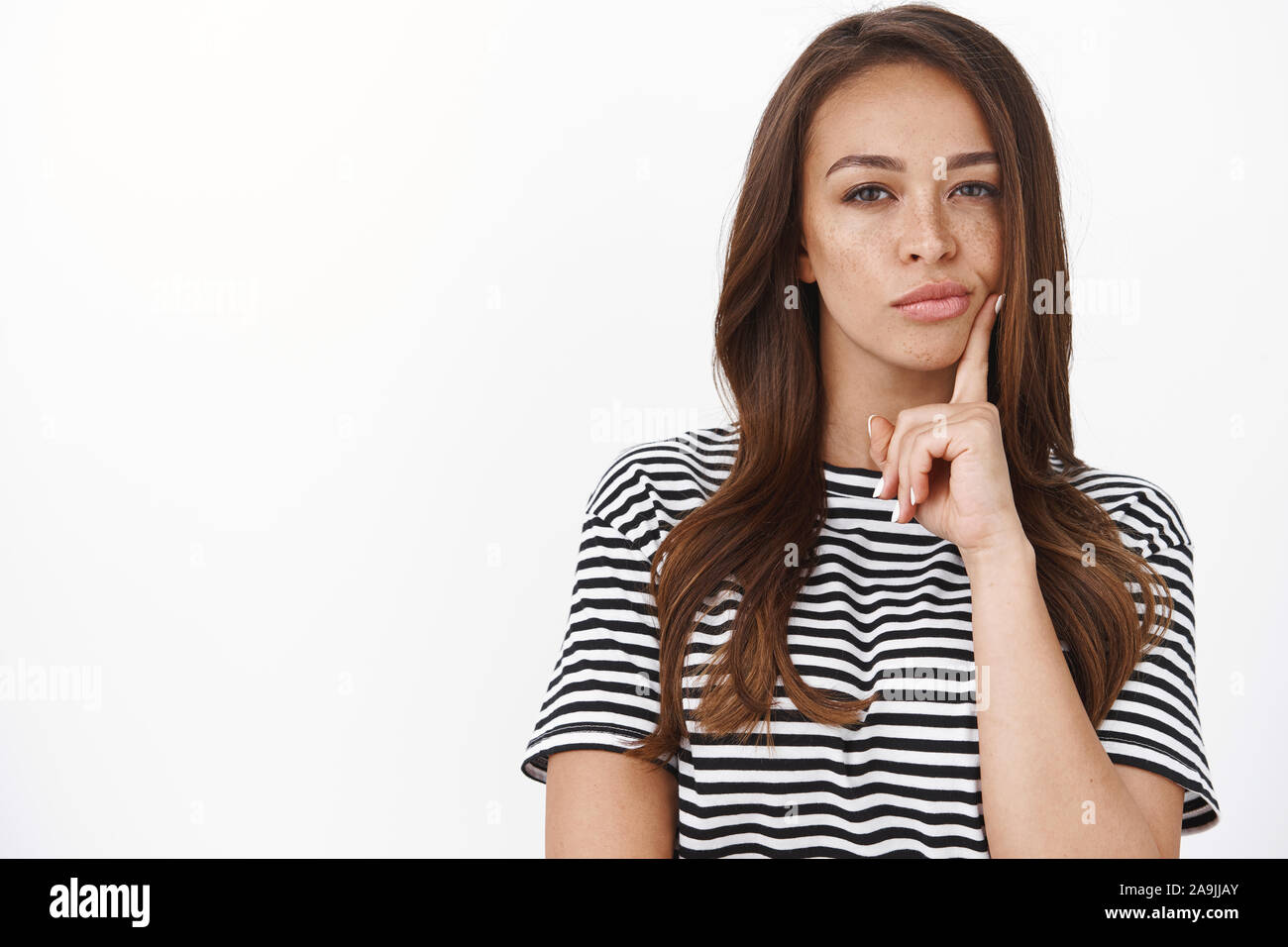Suspicious and thoughtful attractive young woman looking with disbelief ...