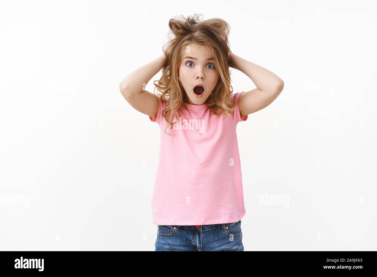 Worried insecure cute little blond kid, girl pulling hair from head ...