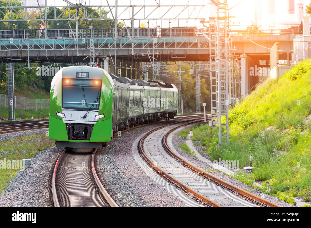 Passenger electric train rides on the turn of the railway line under ...