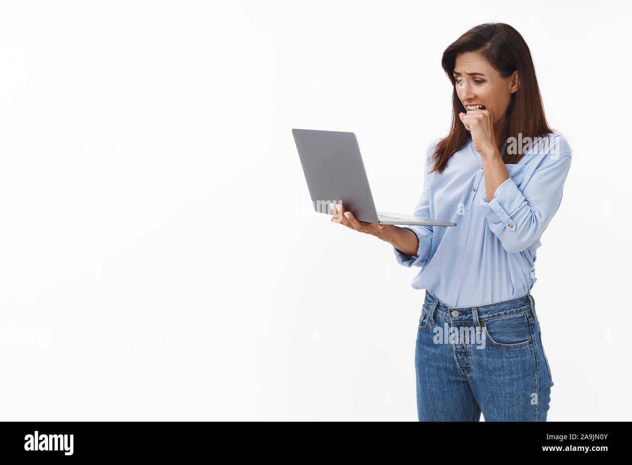 Panicking wife biting fist nervously, standing hold laptop stare screen ...