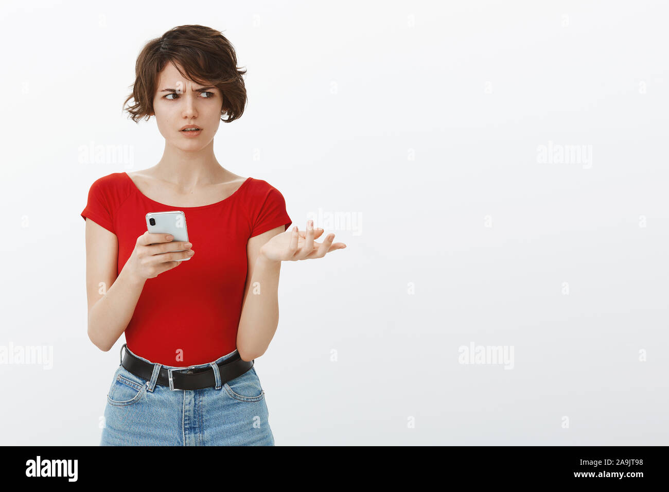 How strange. Confused attractive young woman short haircut shrugging ...