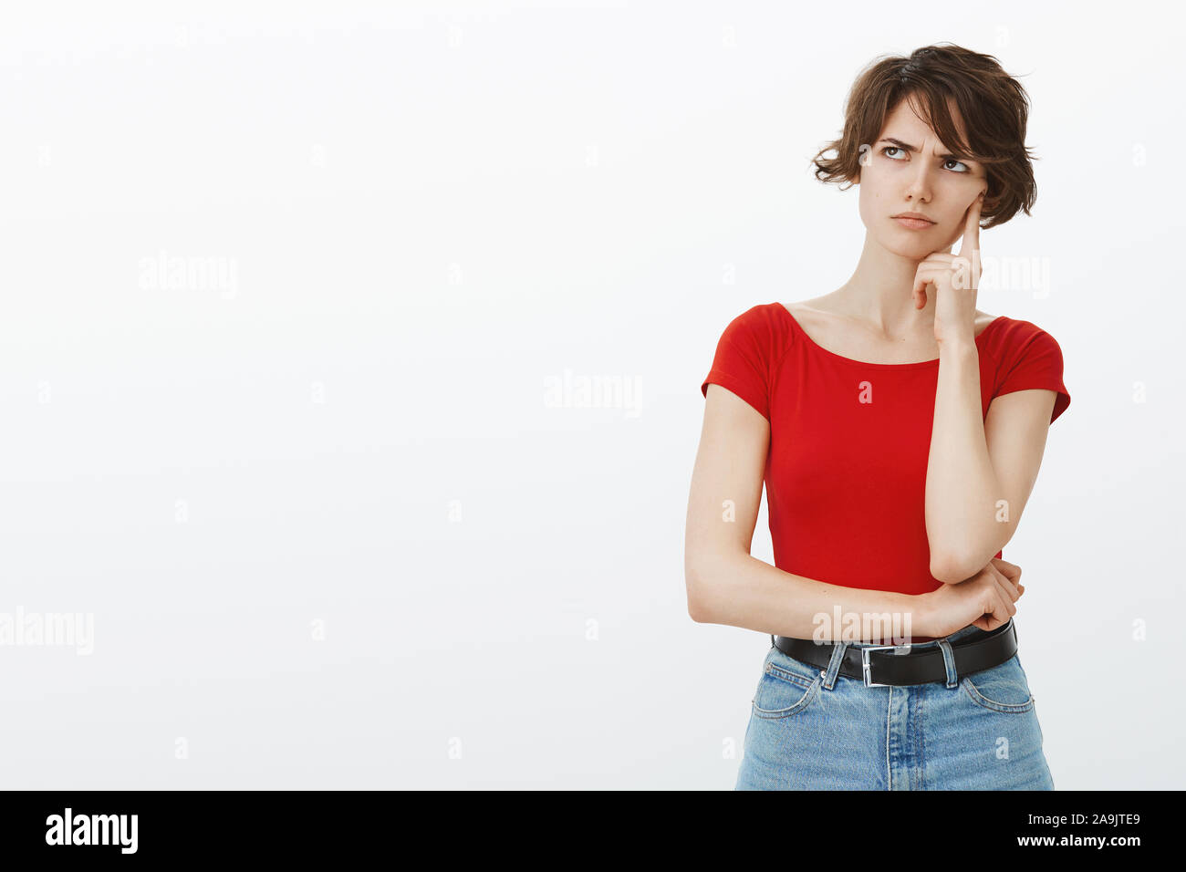 Perplexed serious-looking intense young woman pondering important ...