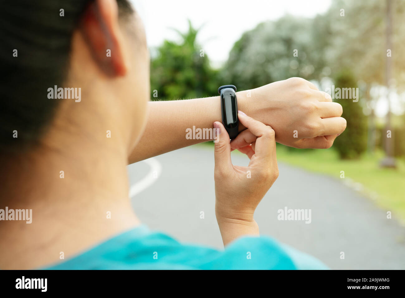 fitness woman runner setting up smartwatch before running. Outdoor ...