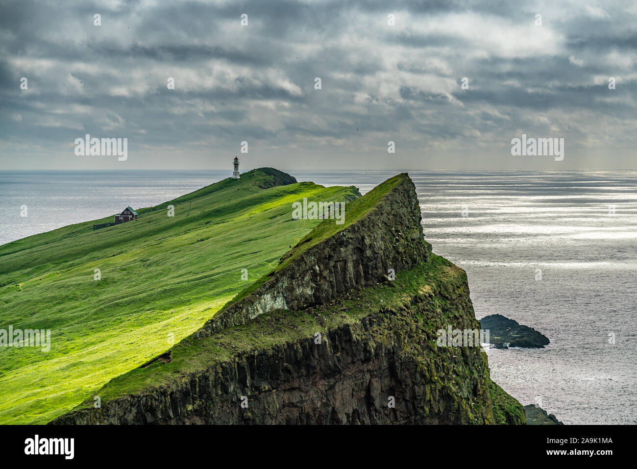 The lighthouse on Mykines island under the clouds, Faroe Islands Stock ...
