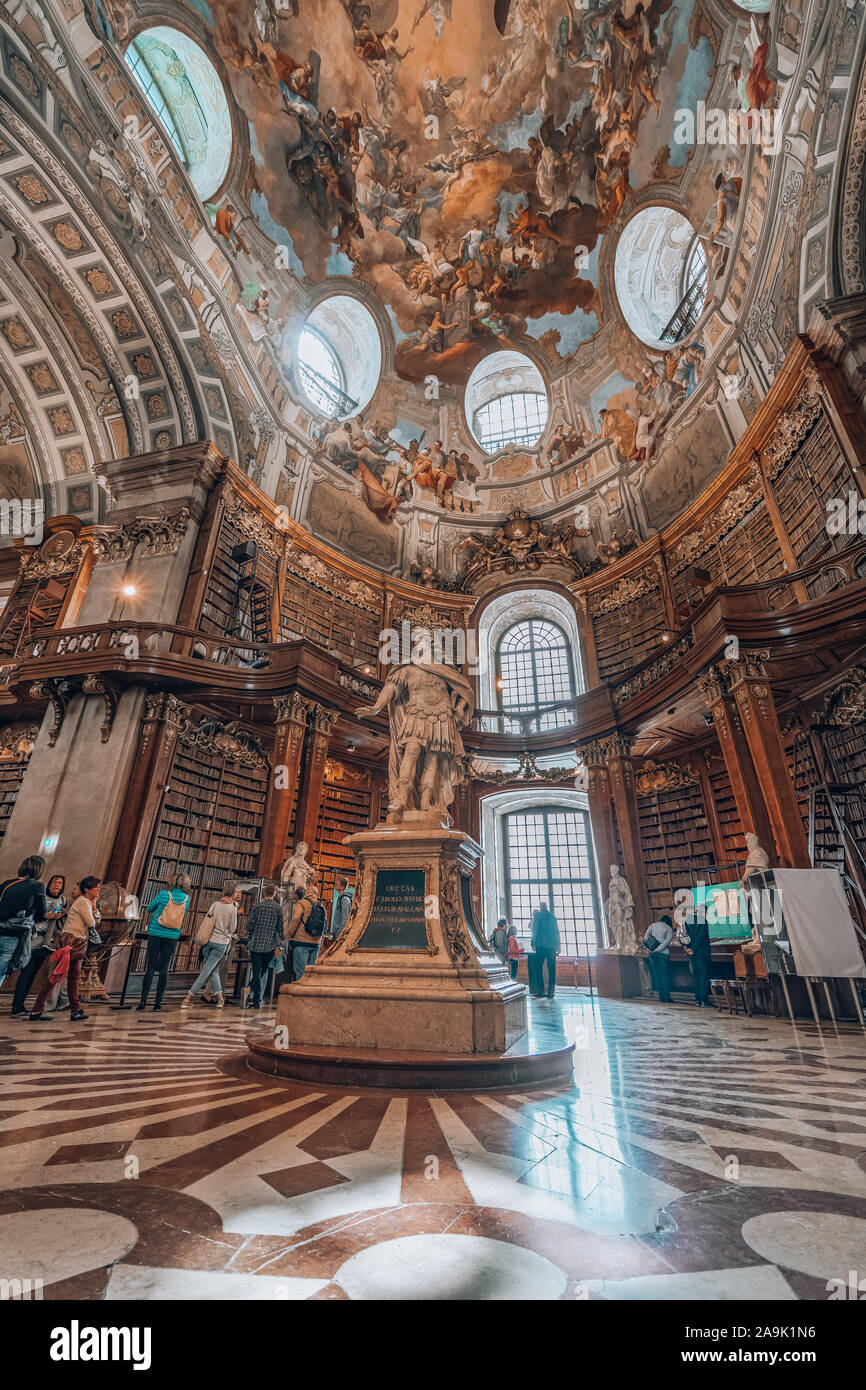 Vienna, Austria - April 28, 2019: Tourists admire the bookshelf and ...