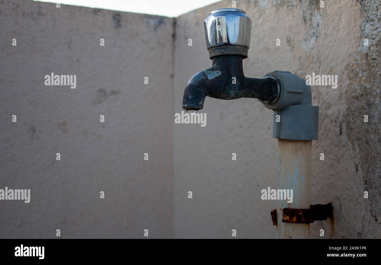 View of exterior water tap with drop of water falling Stock Photo - Alamy