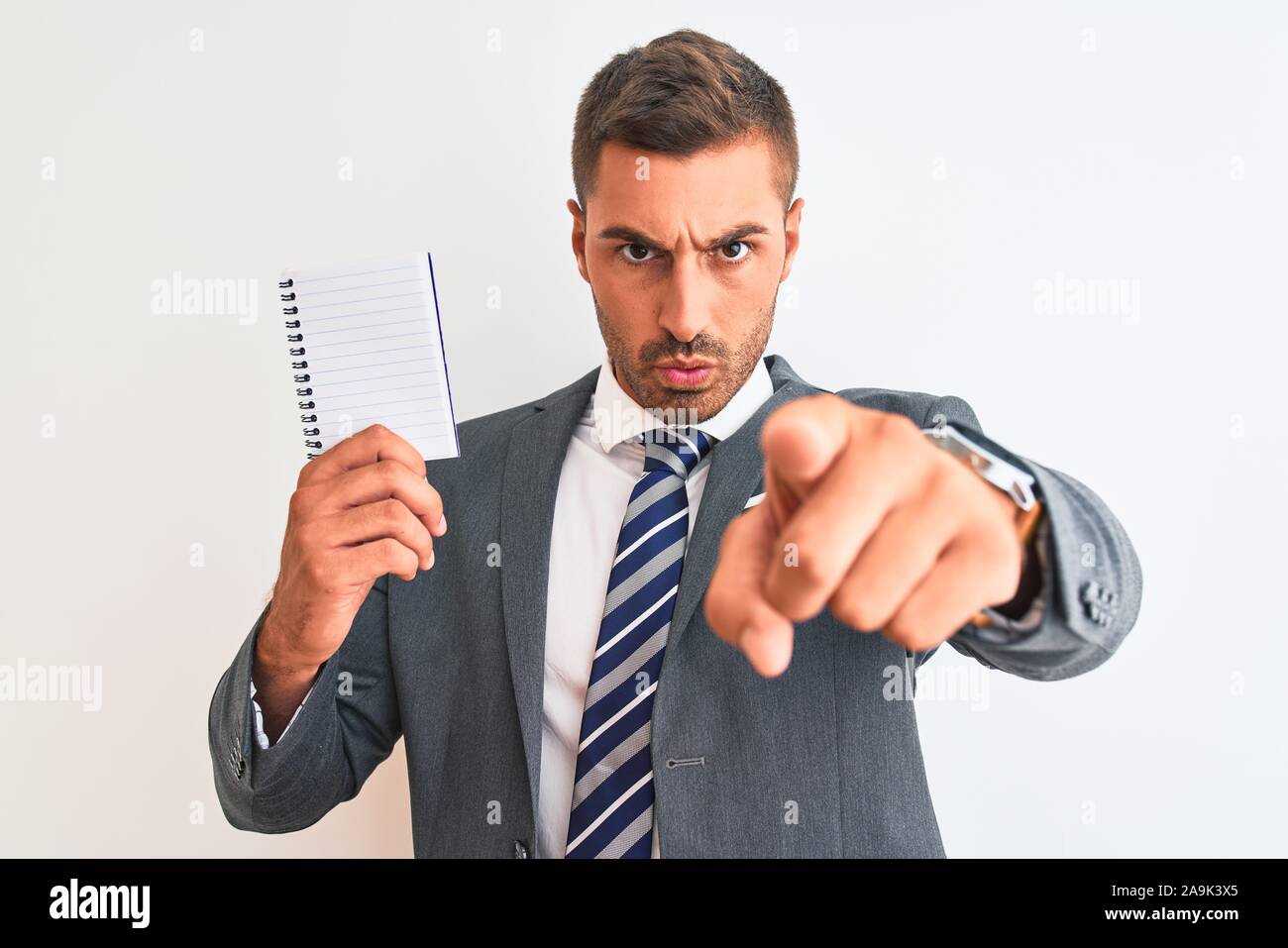 Young handsome business man holding blank notebook over isolated ...