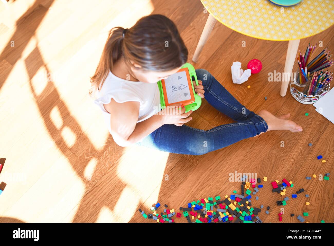 Adorable toddler drawing using digital board around lots of toys at ...