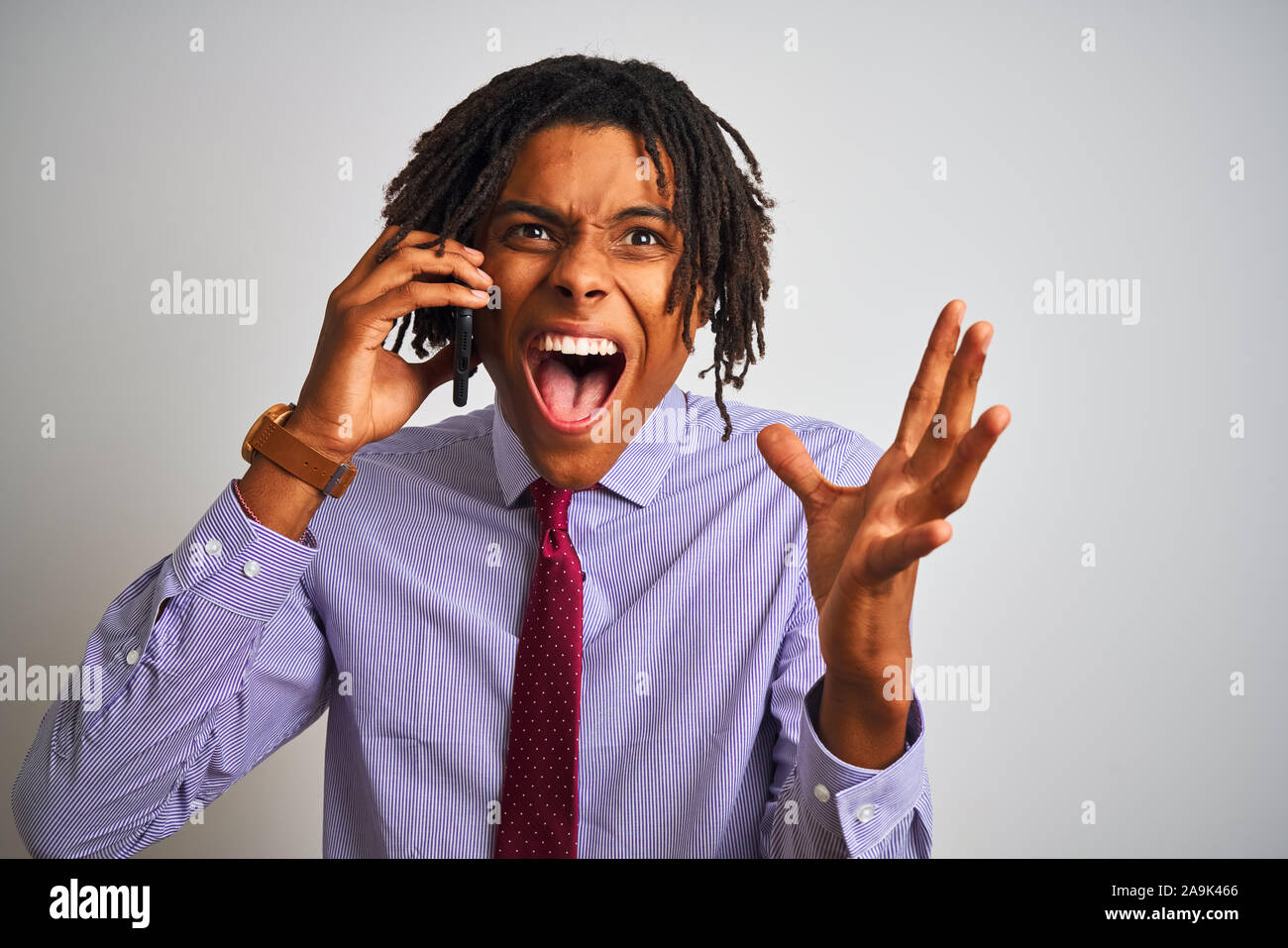 Afro businessman with dreadlocks talking using smartphone over isolated ...