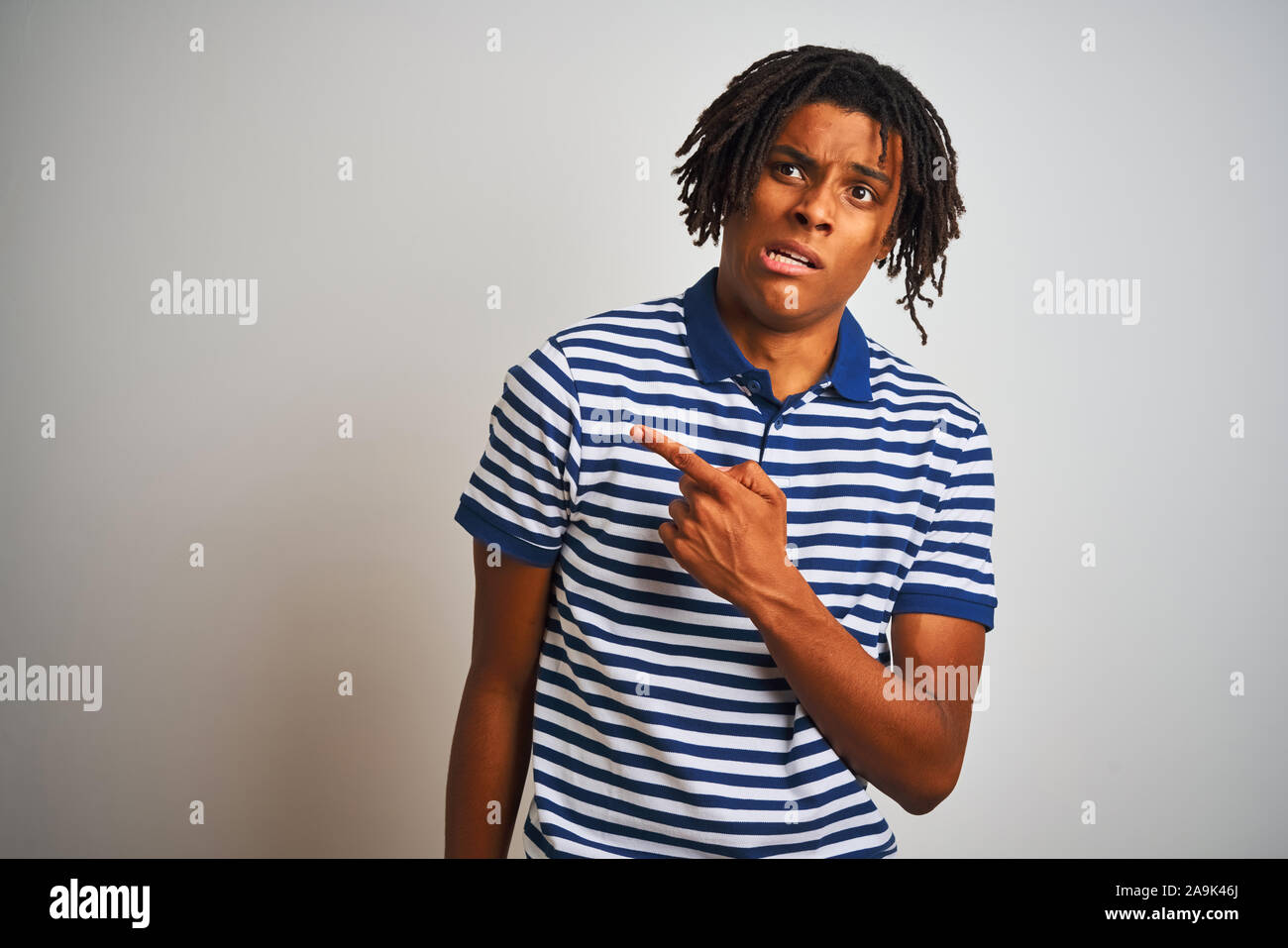Afro man with dreadlocks wearing striped blue polo standing over ...