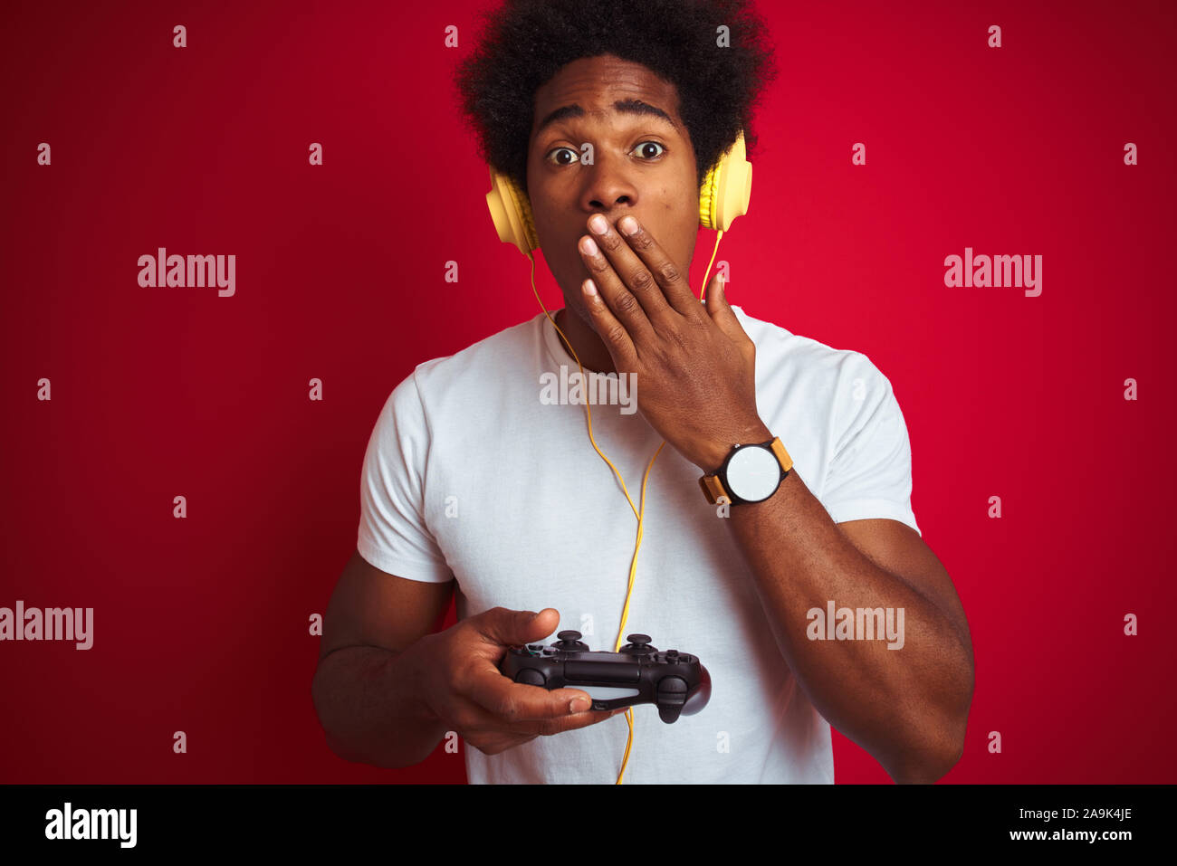 Afro gamer man playing video game using joystick headphones over ...