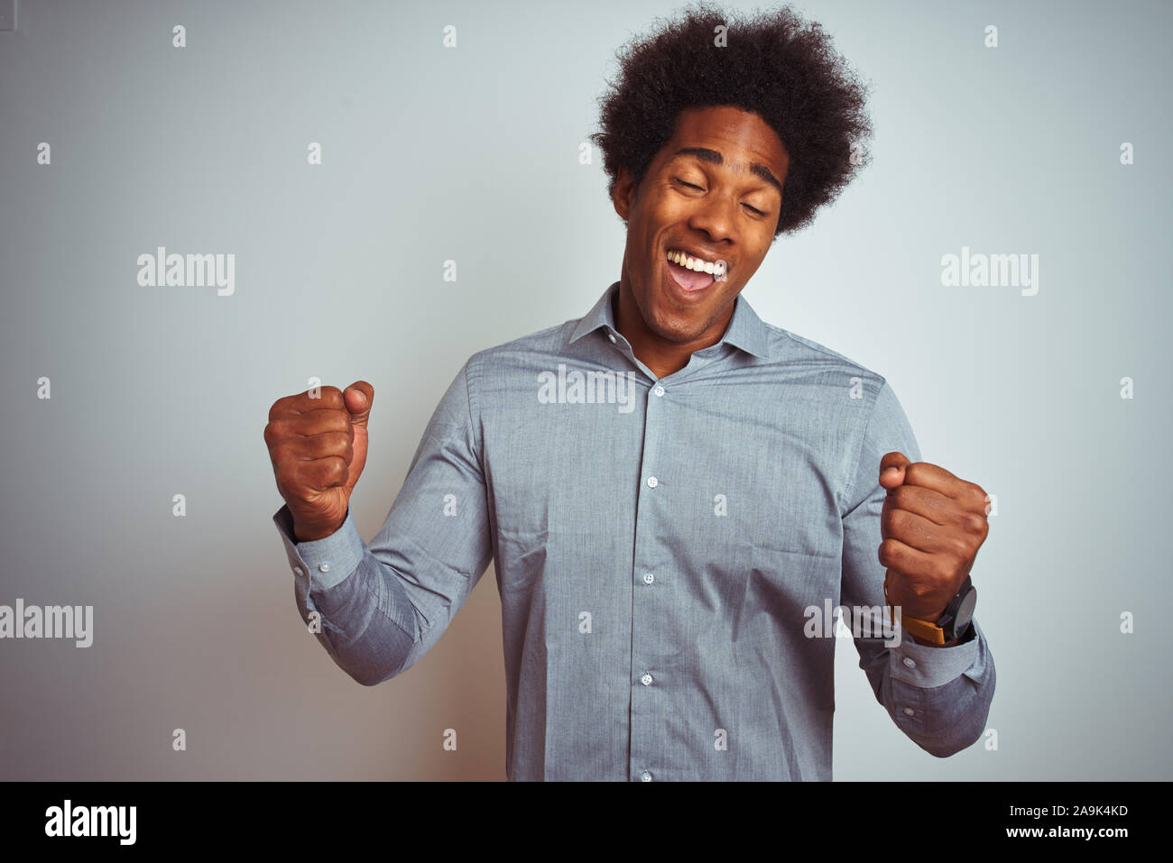 Young african american man with afro hair wearing grey shirt over ...