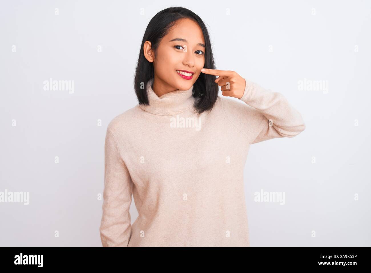 Young chinese woman wearing turtleneck sweater standing over isolated ...