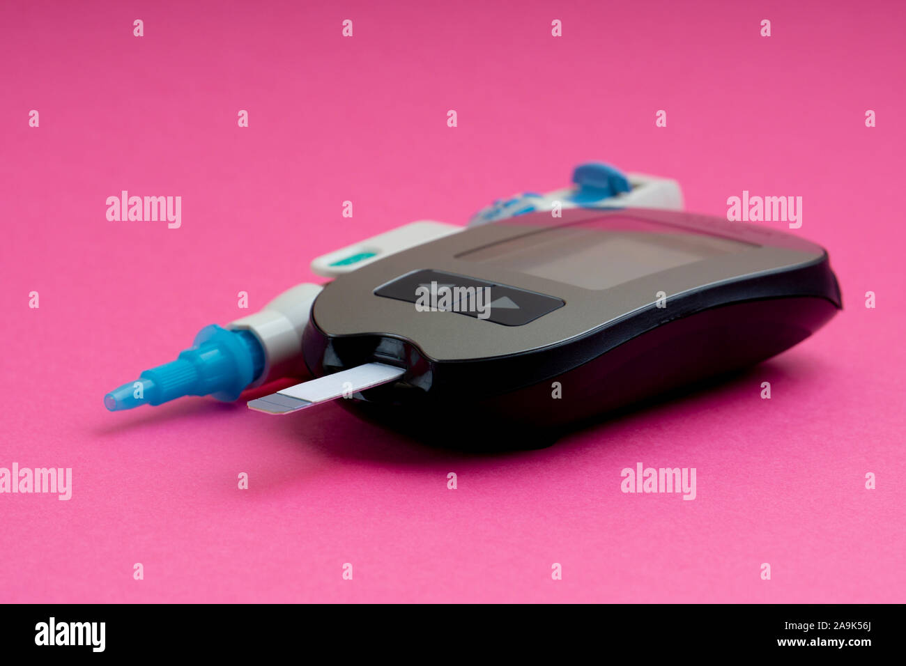 Diabetes concept. Syringe, and Glucometer or Glucose meter on pink ...