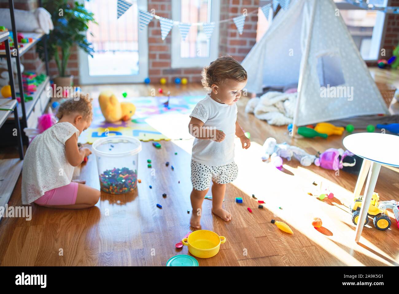 Beautiful toddlers playing around lots of toys at kindergarten Stock ...