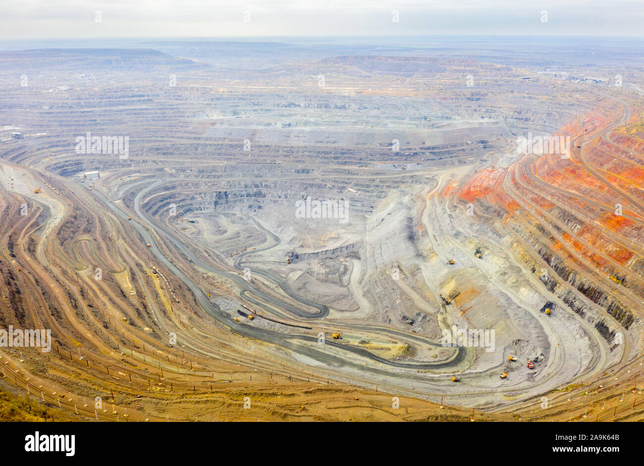 Aerial view of opencast mining quarry with lots of machinery at work ...