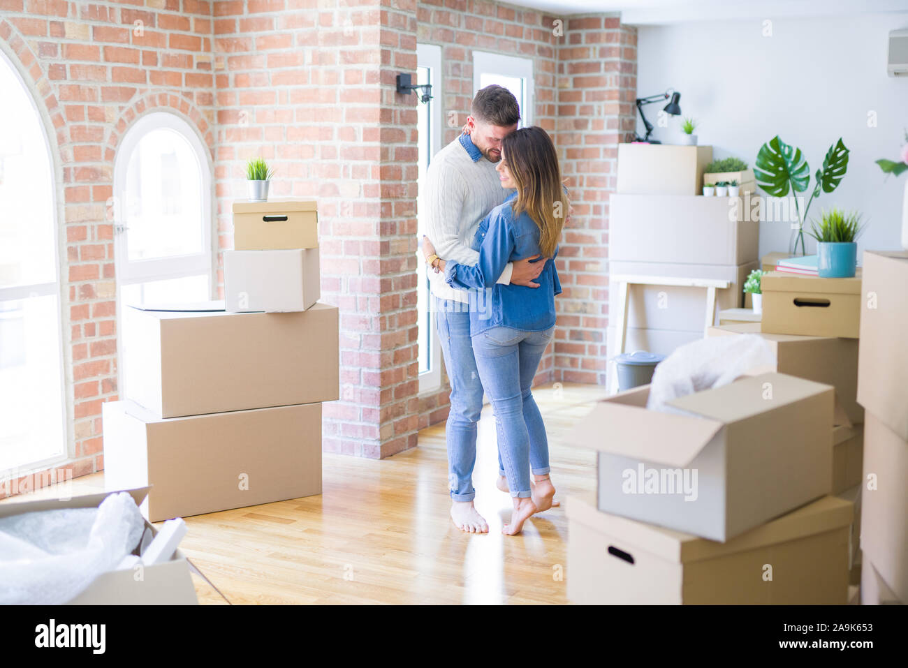 Young beautiful couple dancing at new home around cardboard boxes Stock ...