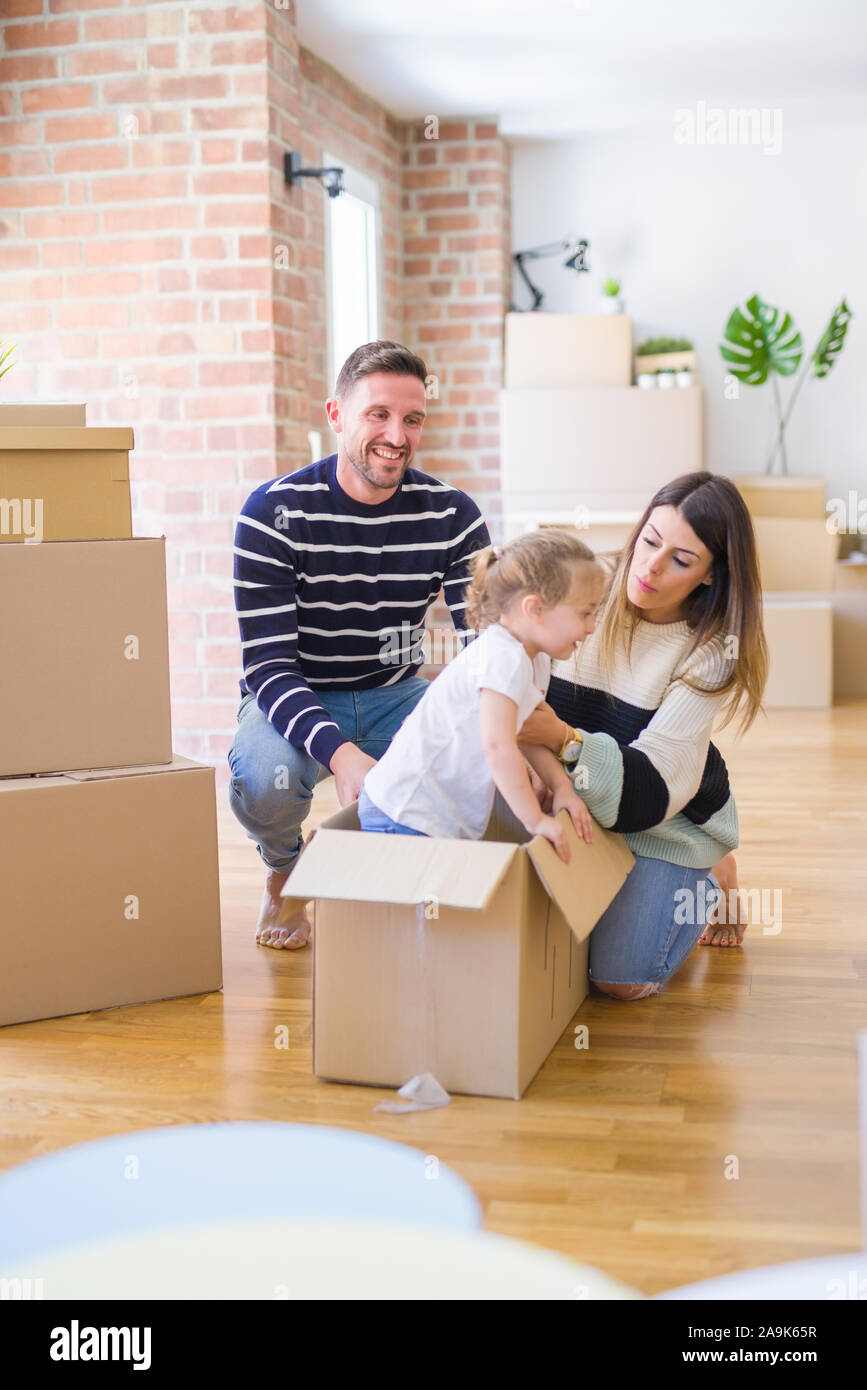 Beautiful famiily, kid playing with his parents riding cardboard fanny ...