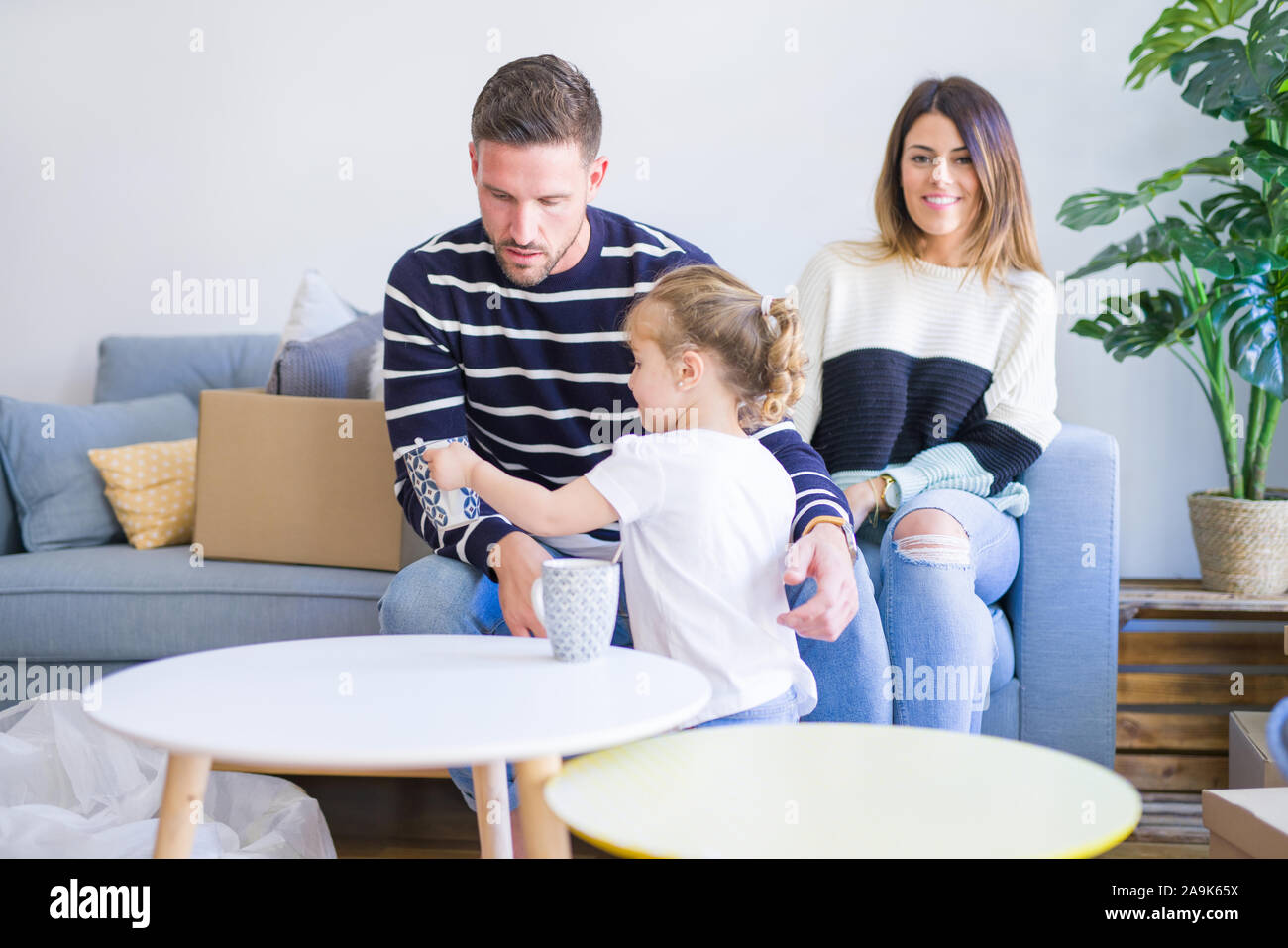 Beautiful family, parents sitting on the sofa drinking coffee looking ...