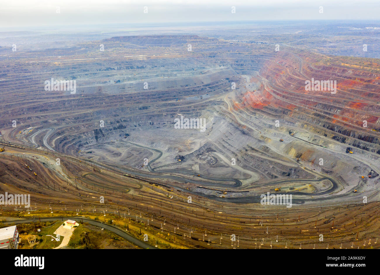 Aerial view of opencast mining quarry with lots of machinery at work ...