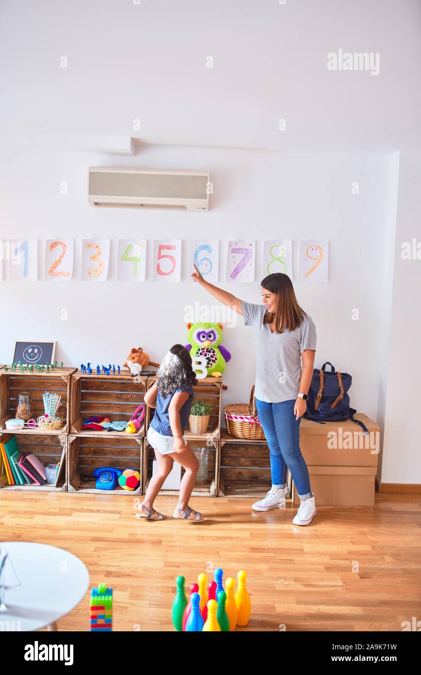 Beautiful teacher teaching maths to toddler girl playing at ...