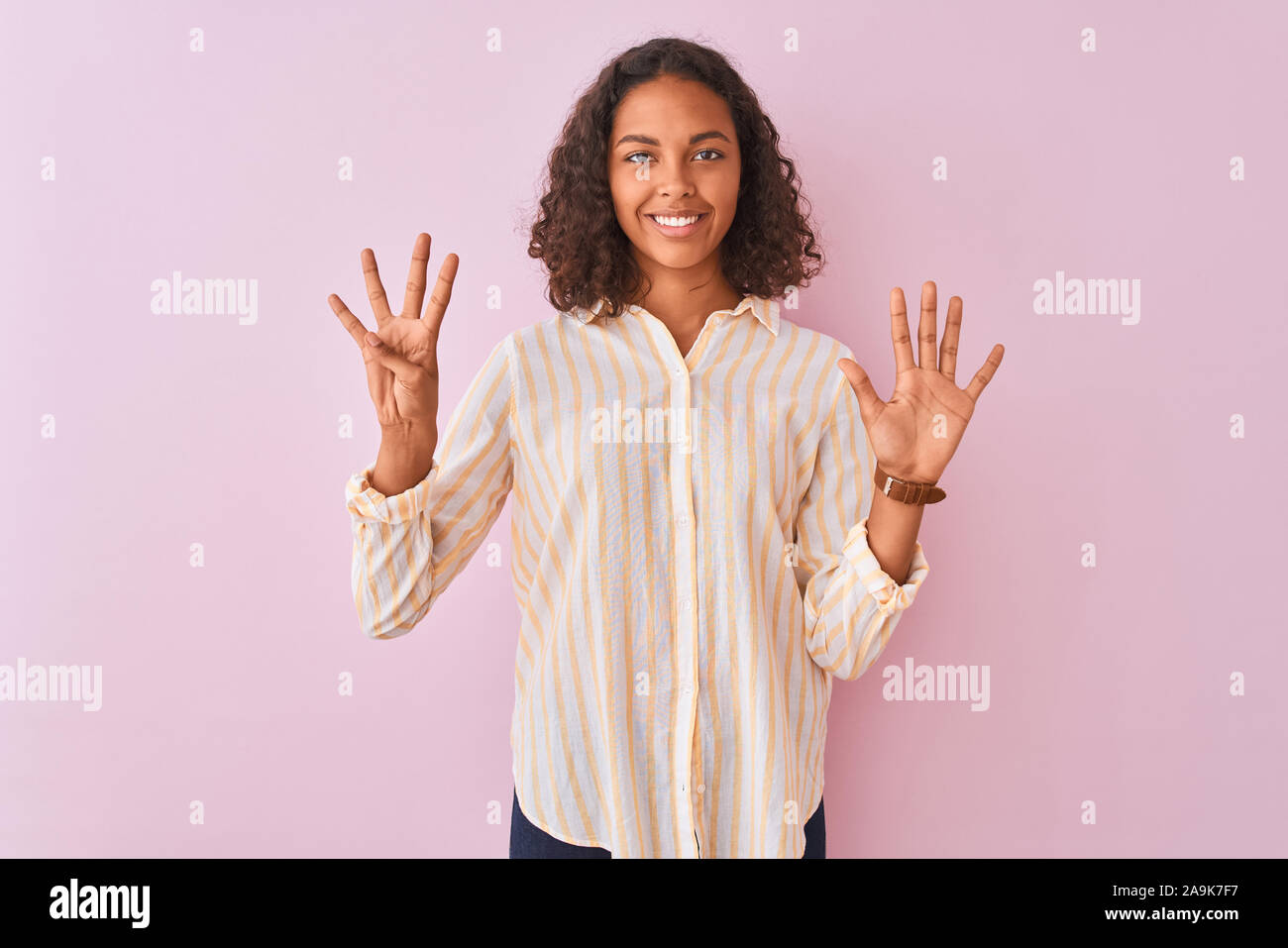 Young Brazilian Woman Wearing Striped Shirt Standing Over Isolated Pink