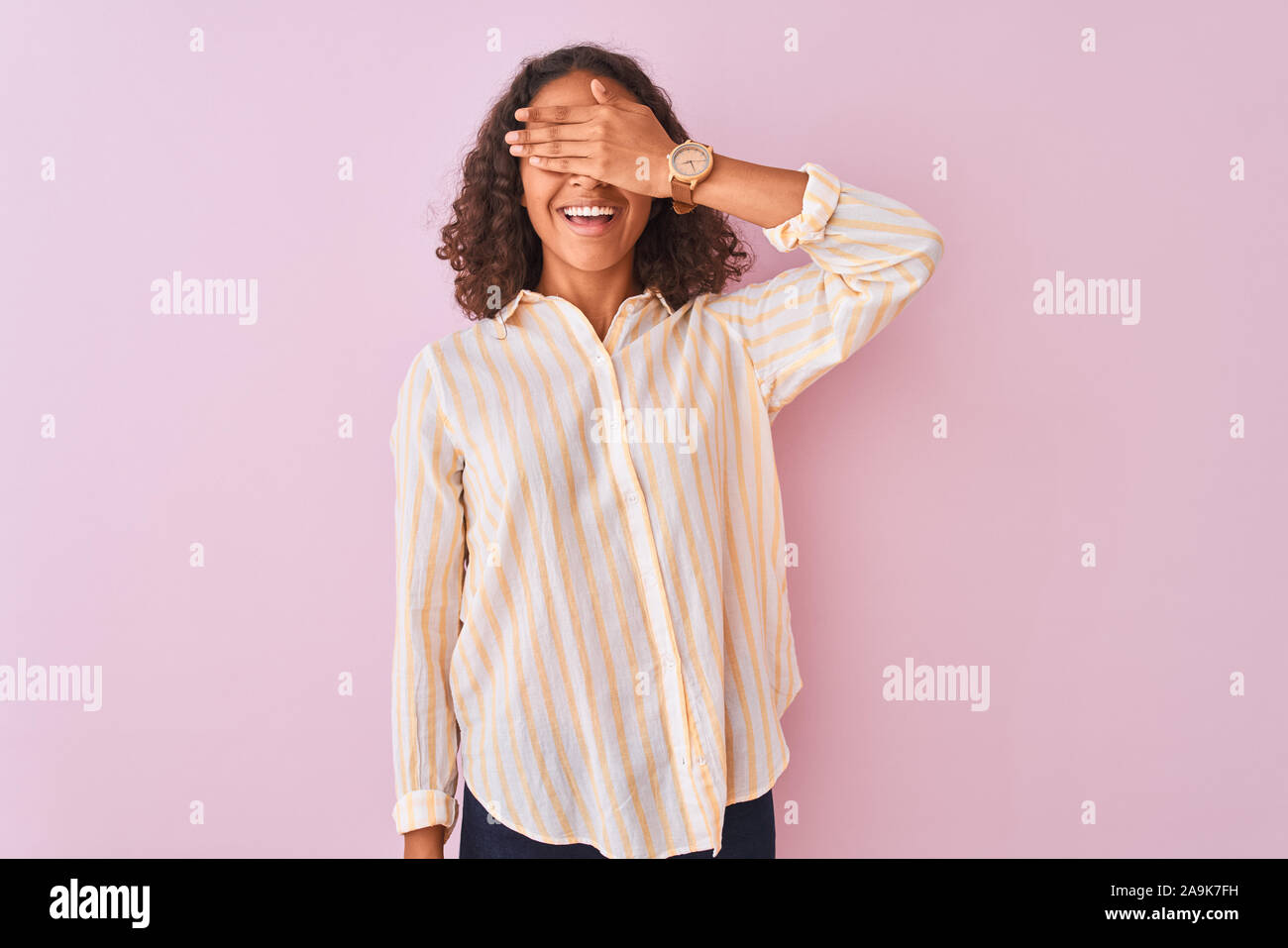 Young Brazilian Woman Wearing Striped Shirt Standing Over Isolated Pink