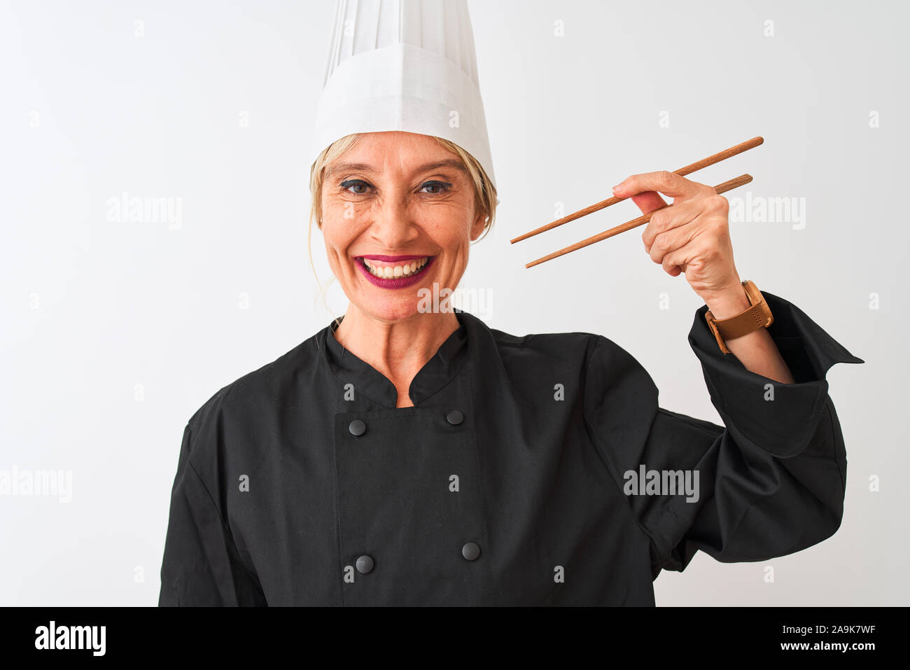 Middle age chef woman wearing cap holding chopsticks over isolated ...
