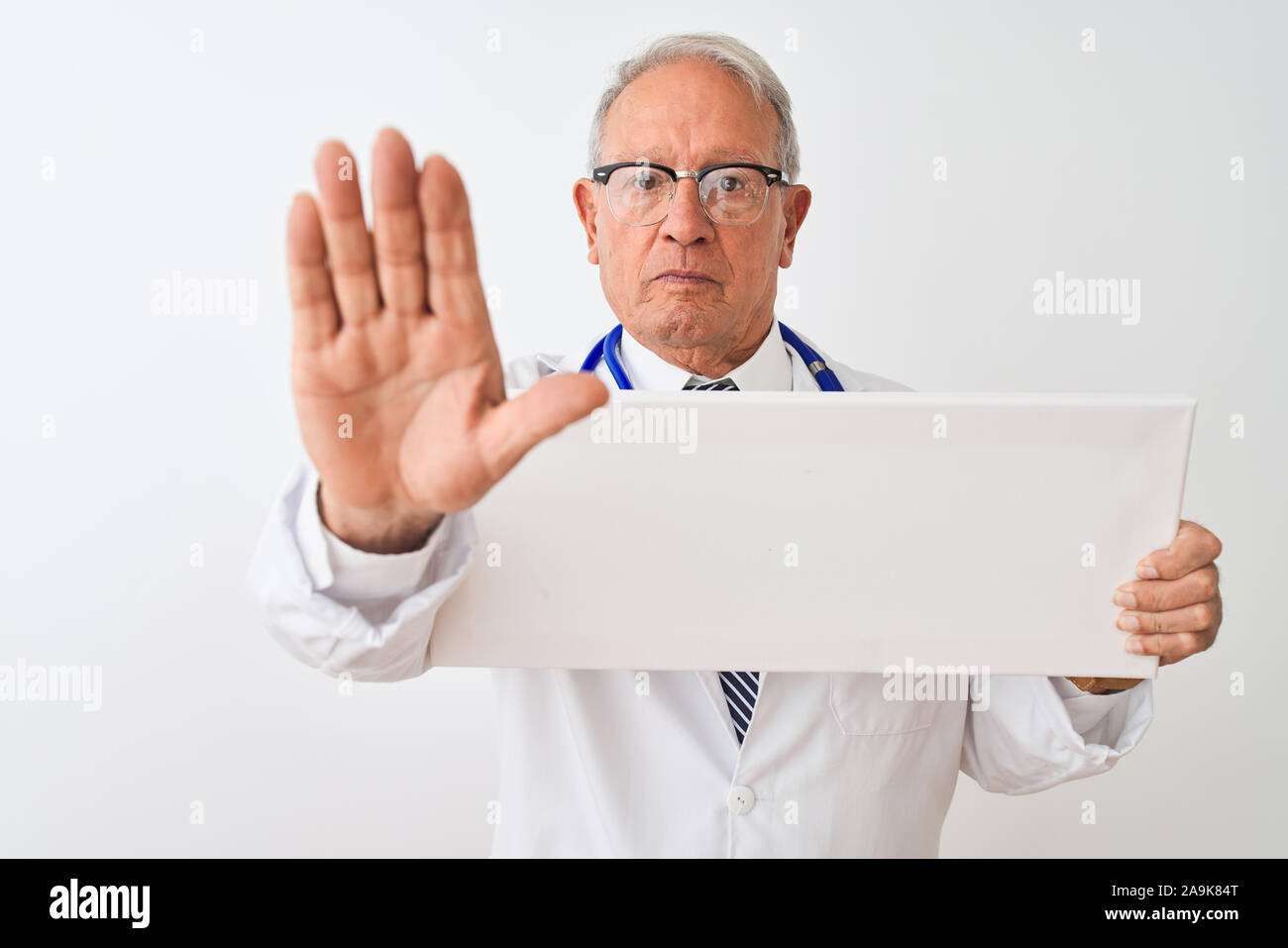 Senior grey-haired doctor man holding banner standing over isolated ...
