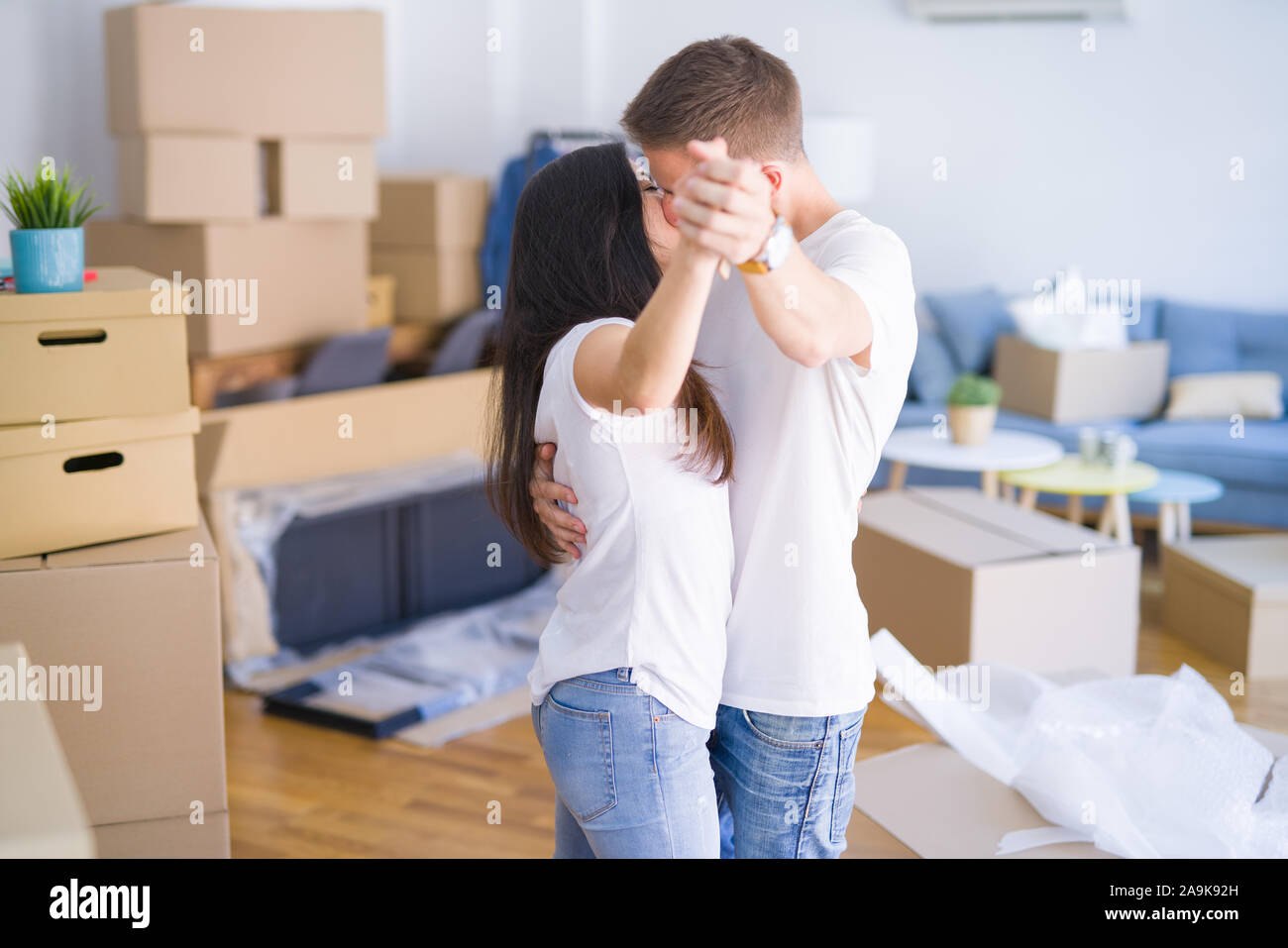 Young beautiful couple dancing at new home around cardboard boxes Stock ...