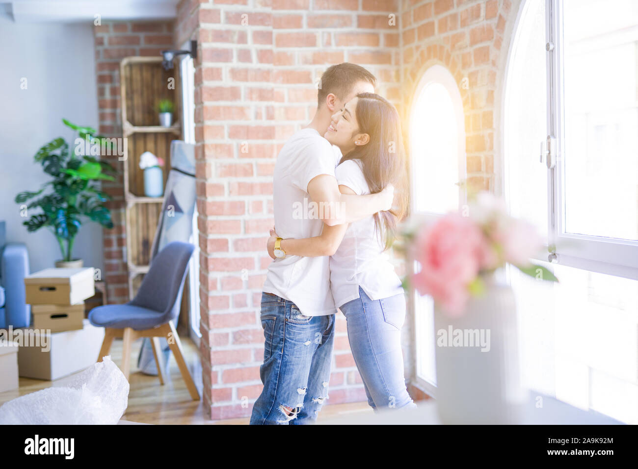 Young beautiful couple hugging at new home around cardboard boxes Stock ...