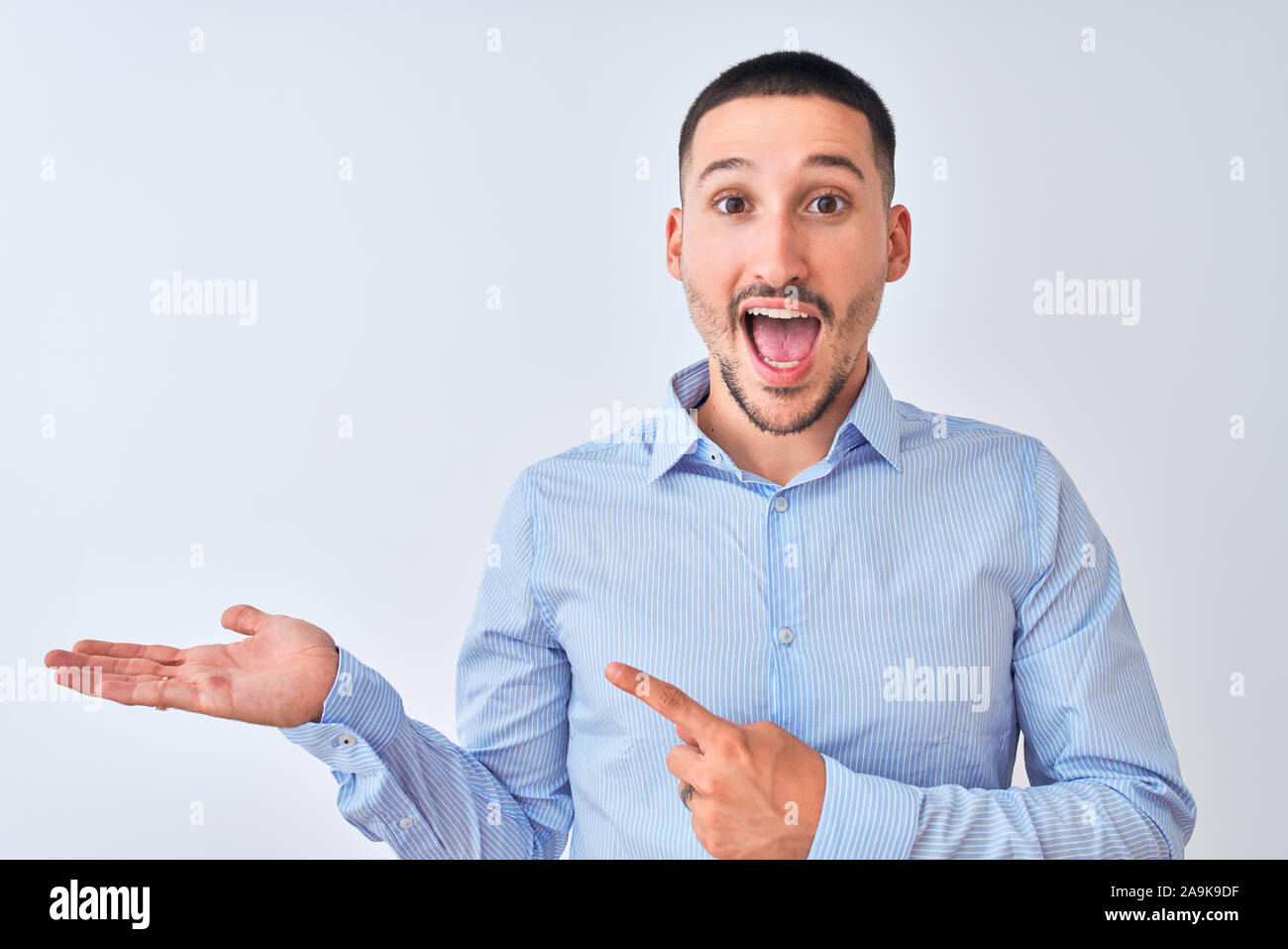 Young handsome business man standing over isolated background amazed ...