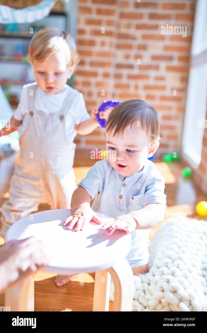 Beautiful toddlers playing around lots of toys at kindergarten Stock ...