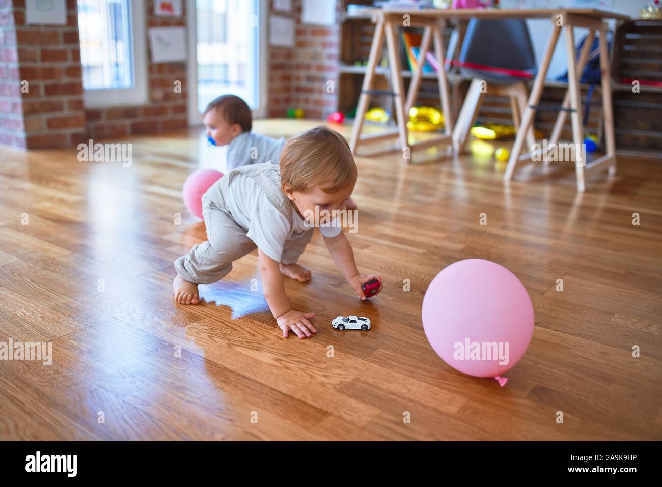 Beautiful toddlers playing around lots of toys at kindergarten Stock ...