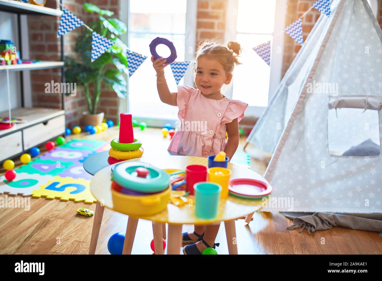 Young beautiful toddler smiling building pyramid using hoops on the ...