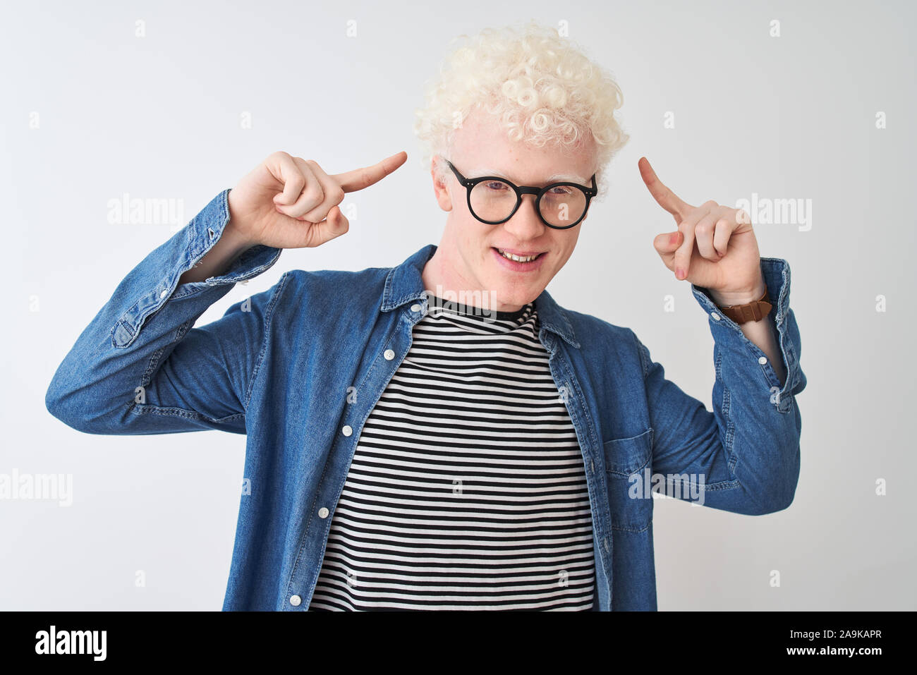 Young albino blond man wearing denim shirt and glasses over isolated ...
