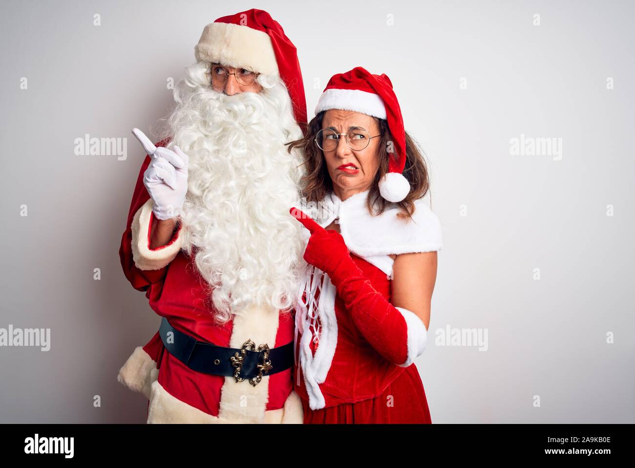 Middle age couple wearing Santa costume hugging over isolated white ...