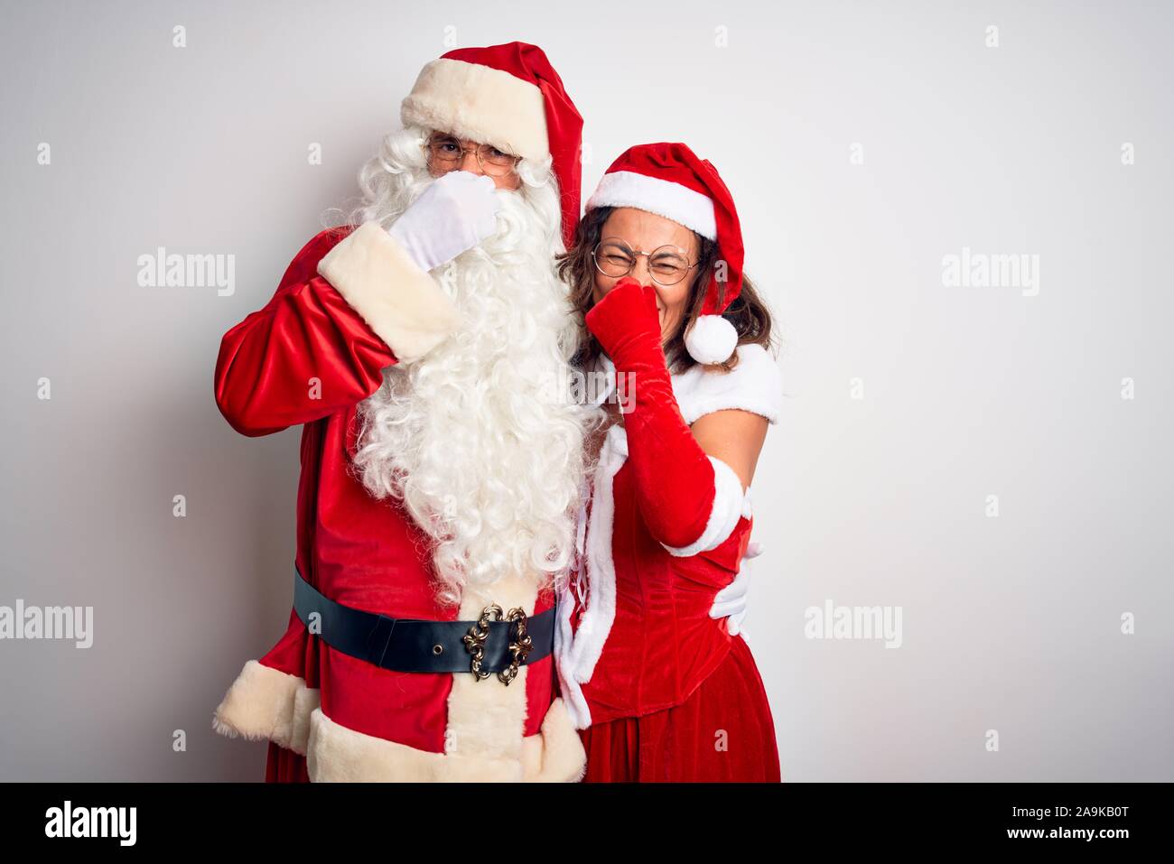 Middle age couple wearing Santa costume hugging over isolated white ...