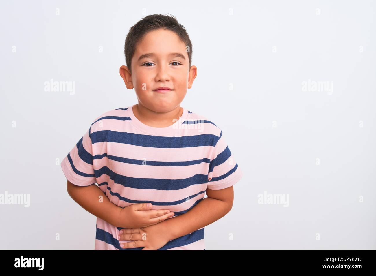 Beautiful kid boy wearing casual striped t-shirt standing over isolated ...