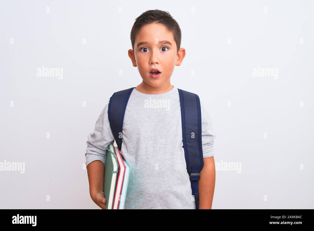 Beautiful student kid boy wearing backpack holding books over isolated ...