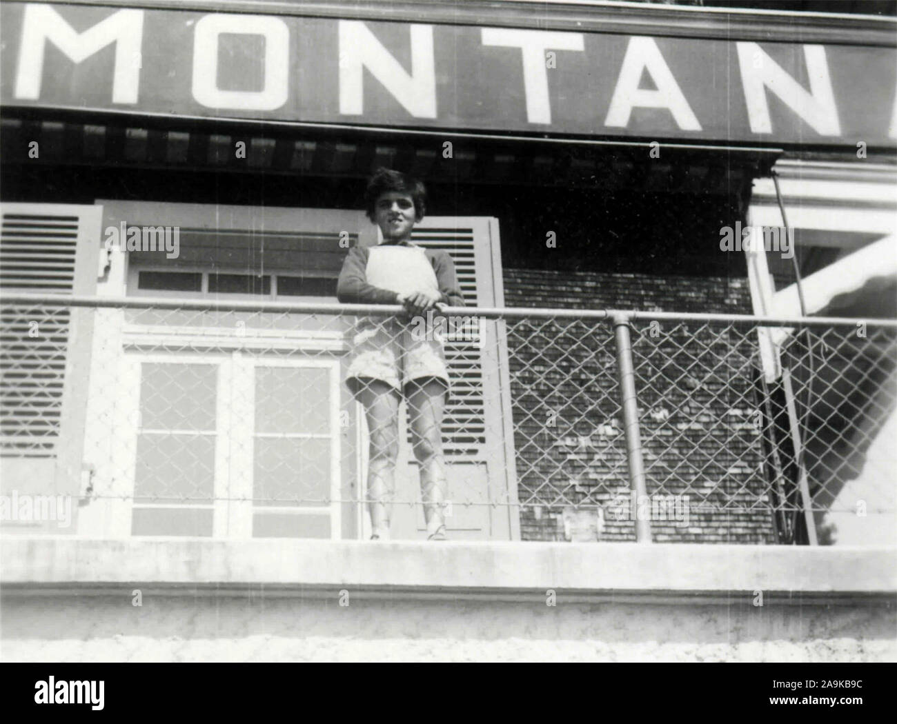 A child looks out from a balcony Stock Photo - Alamy