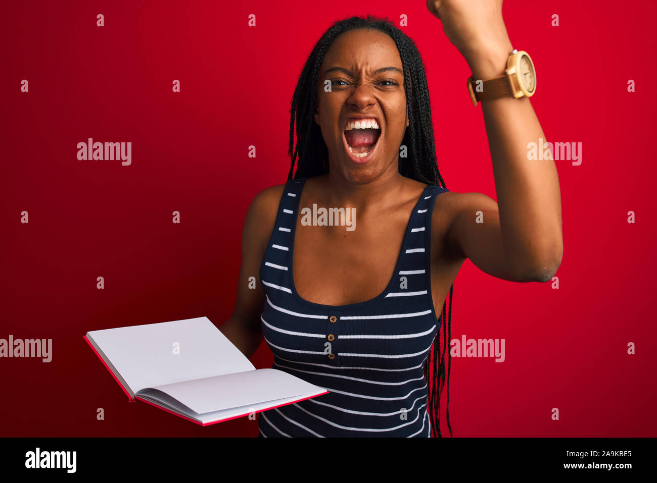 Young african american student woman reading book standing over ...