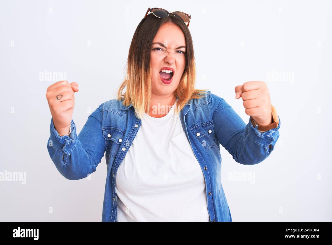 Beautiful woman wearing denim shirt standing over isolated white ...